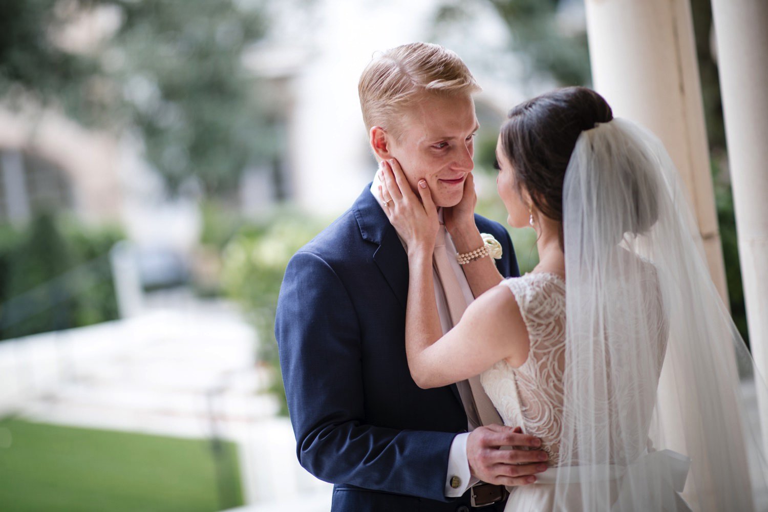 A bride and groom hugging in front of a pillar at their Alfond Inn ...