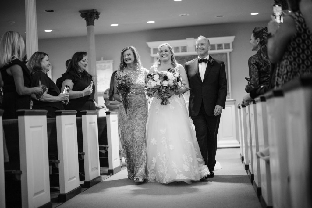 A bride walks down the aisle with her father in a New York wedding ...