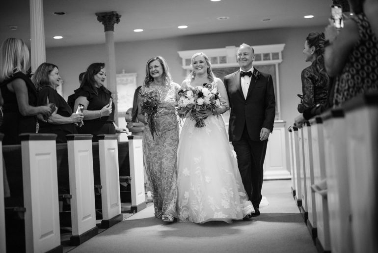 A bride walks down the aisle with her father in a New York wedding ...